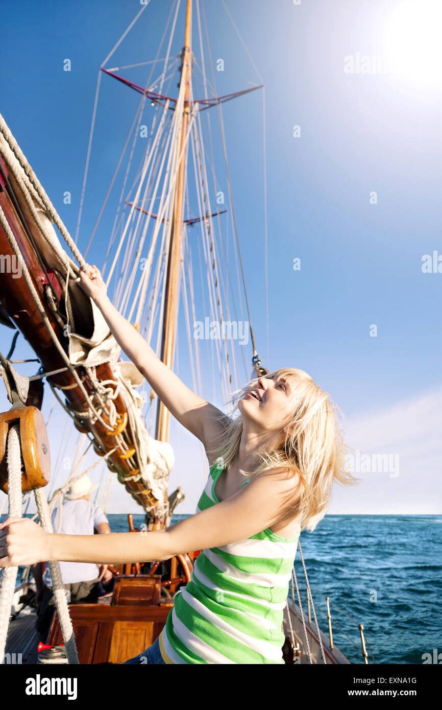 Happy young woman on a sailing ship Stock Photo - Alamy