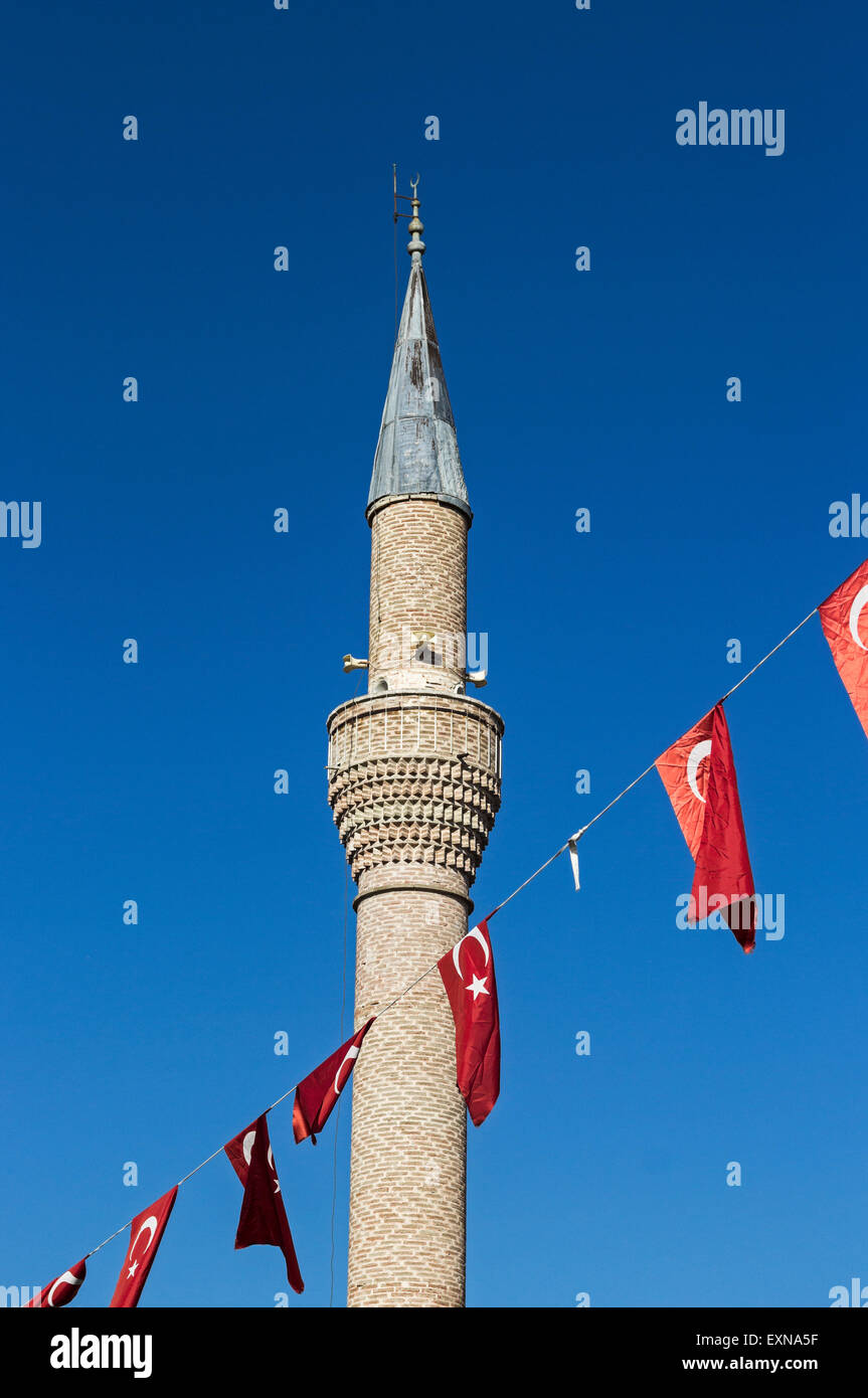 Minaret of a mosque in Bodrum Turkey with a line of Turkish flags in ...