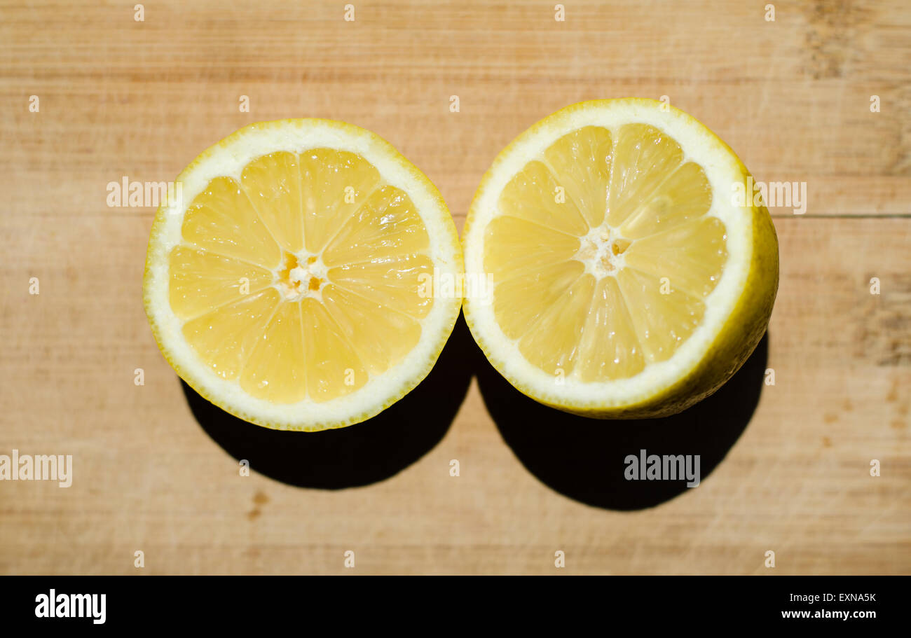 cut lemon with basil leafs on a wooden desk Stock Photo - Alamy