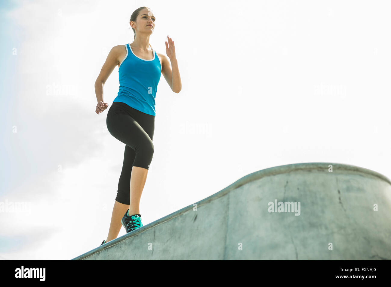 Sportive young woman running on a wall Stock Photo - Alamy