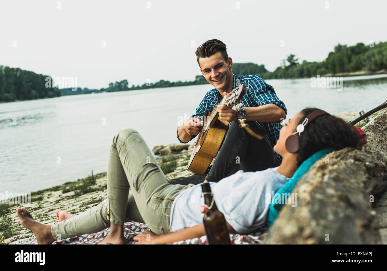 Relaxed Young Couple With Guitar By The Riverside Stock Photo Alamy