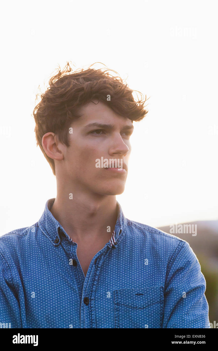 Portrait of serious looking young man at backlight Stock Photo - Alamy