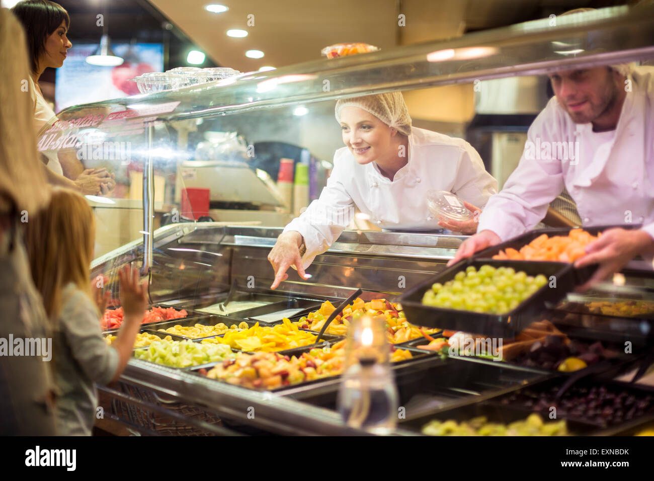 Customers choosing food from display at supermarket Stock Photo - Alamy