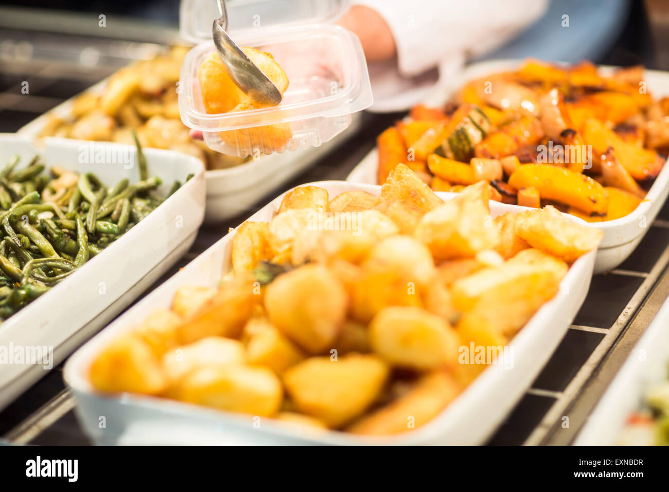 Shop assistant packing food from display at supermarket Stock Photo - Alamy