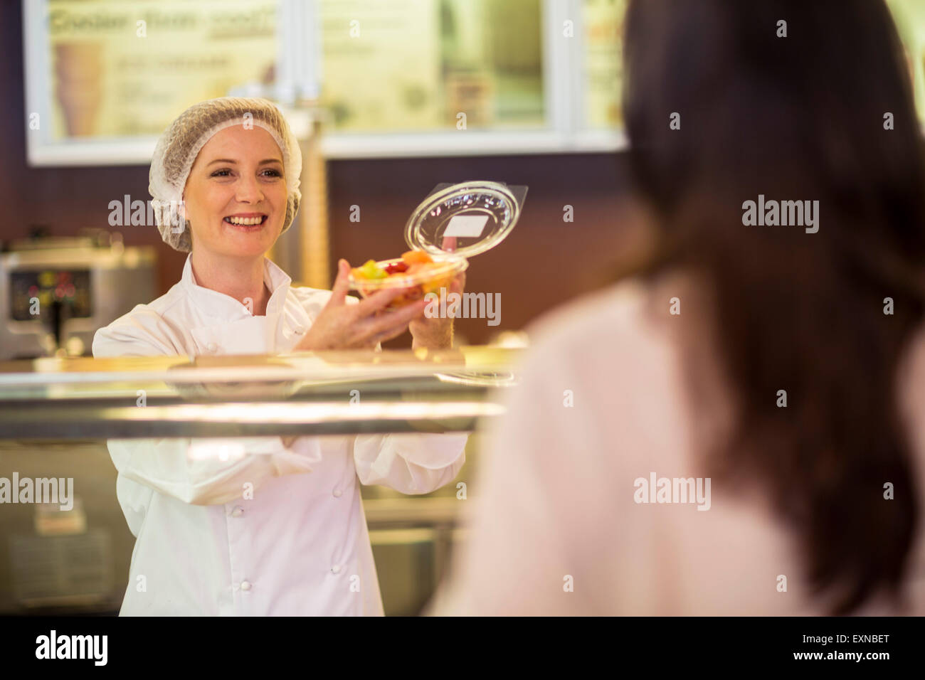 Shop assistant packing fruit salad for customer Stock Photo - Alamy