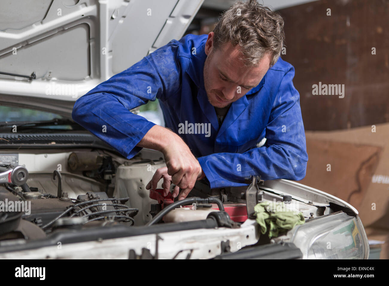 Man working on car in home garage Stock Photo - Alamy