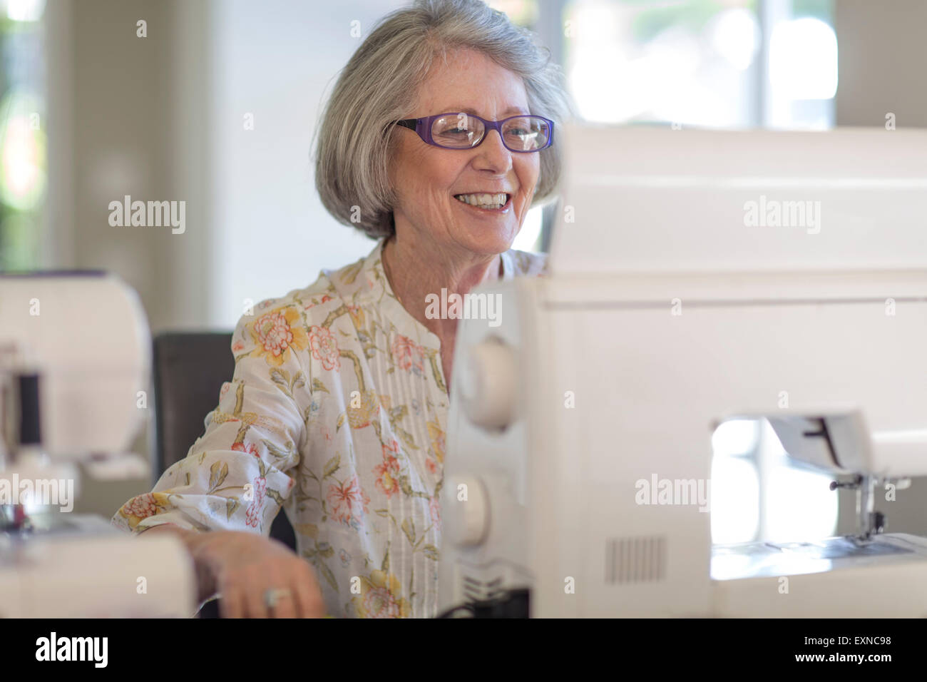 Senior woman working on sewing machine Stock Photo - Alamy