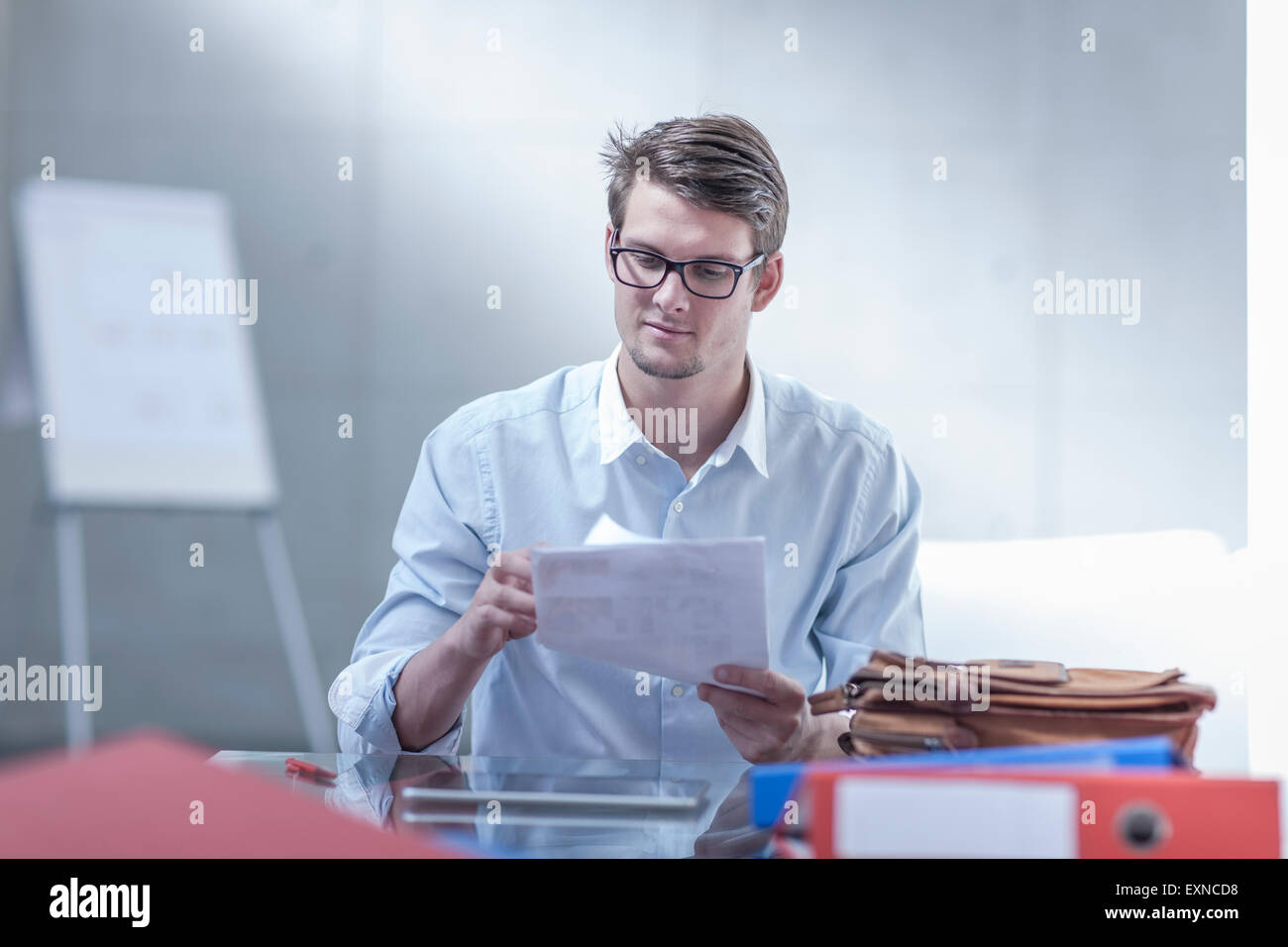 Portrait of young businessman checking documents at his desk Stock ...