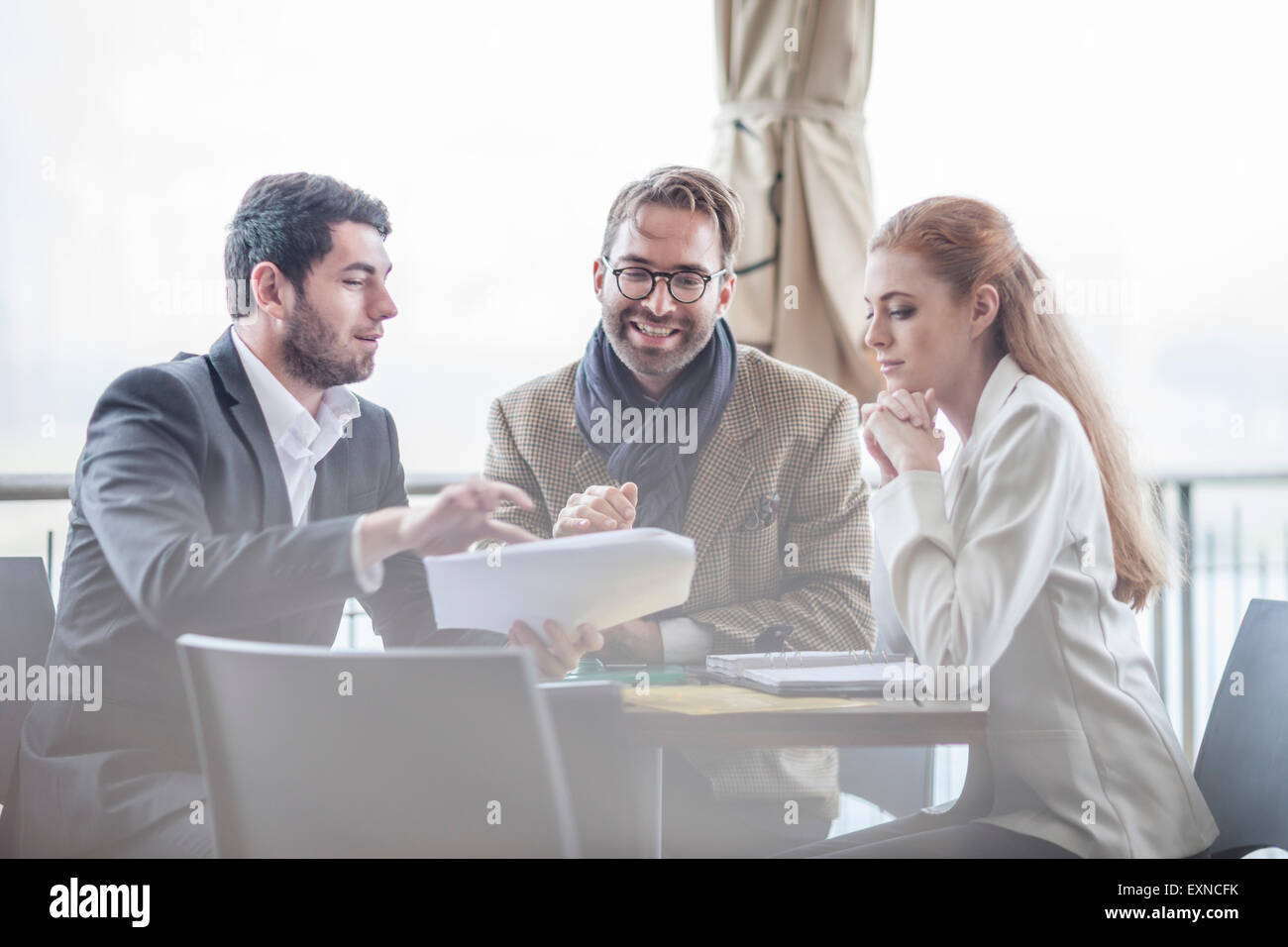 Three people having a meeting at restaurant Stock Photo - Alamy