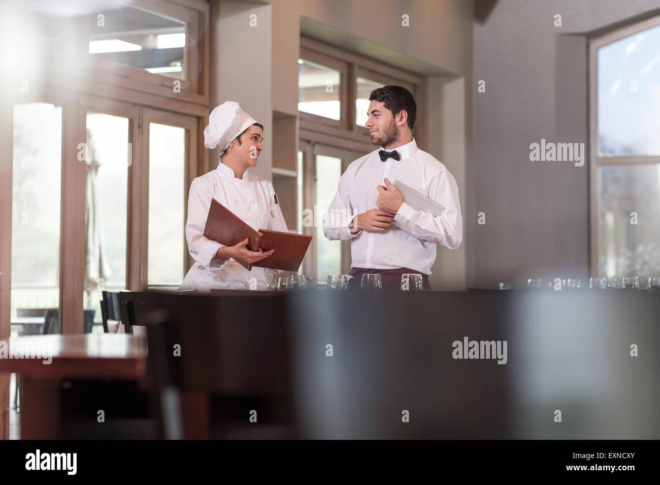 Chef and waiter in restaurant discussing menue Stock Photo - Alamy