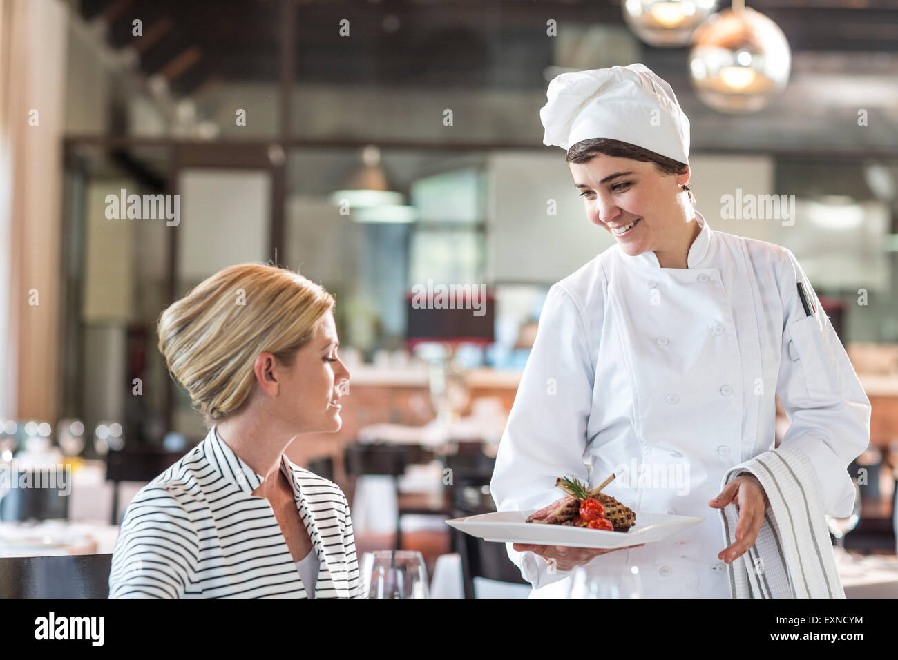Chef serving food for blonde woman Stock Photo - Alamy