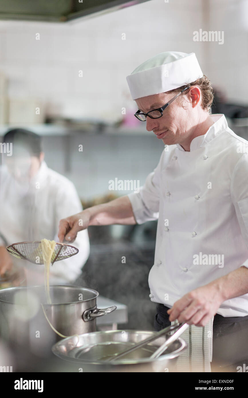 Chef preparing spaghetti in restaurant kitchen Stock Photo - Alamy