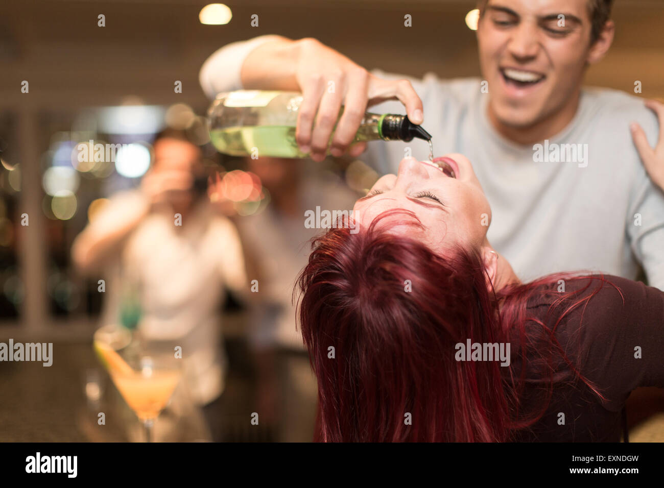Young man befuddling a woman with alcohol Stock Photo - Alamy