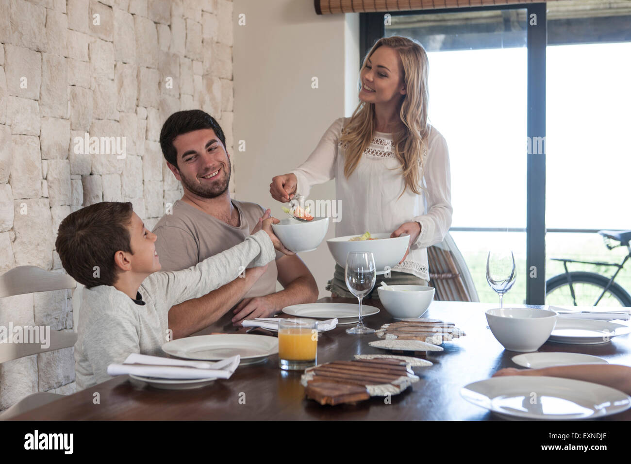 Family having lunch at dining room table Stock Photo - Alamy