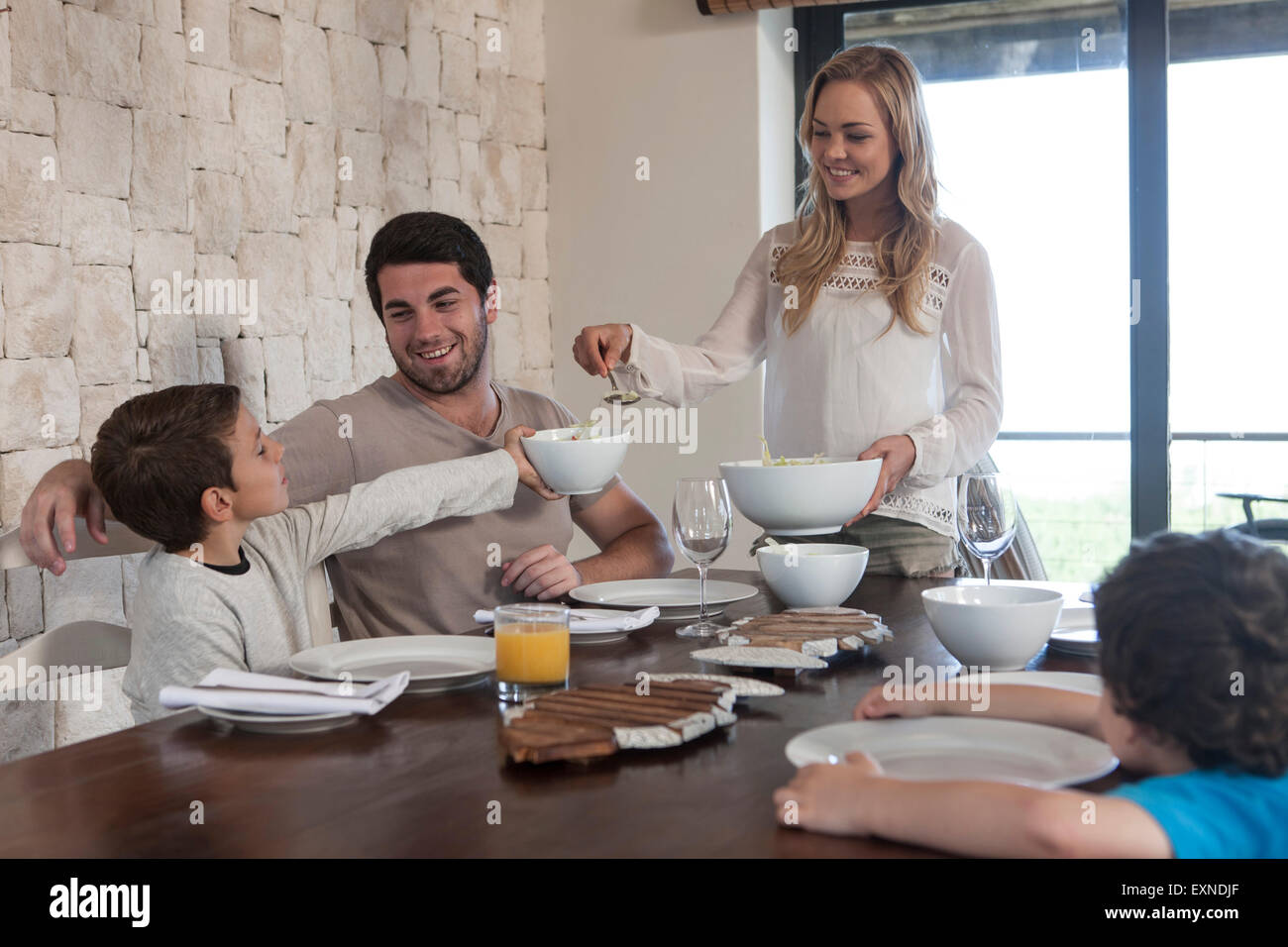 Family having lunch at dining room table Stock Photo - Alamy