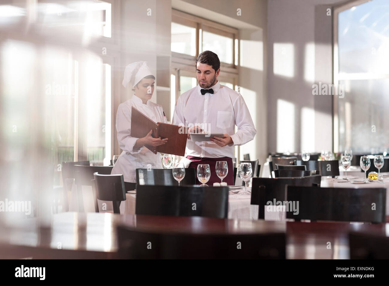 Chef and waiter in restaurant discussing menue Stock Photo - Alamy