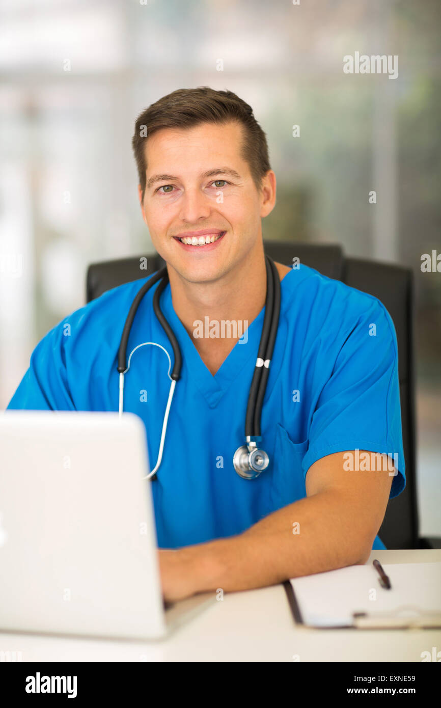 happy male nurse working on laptop computer in office Stock Photo - Alamy