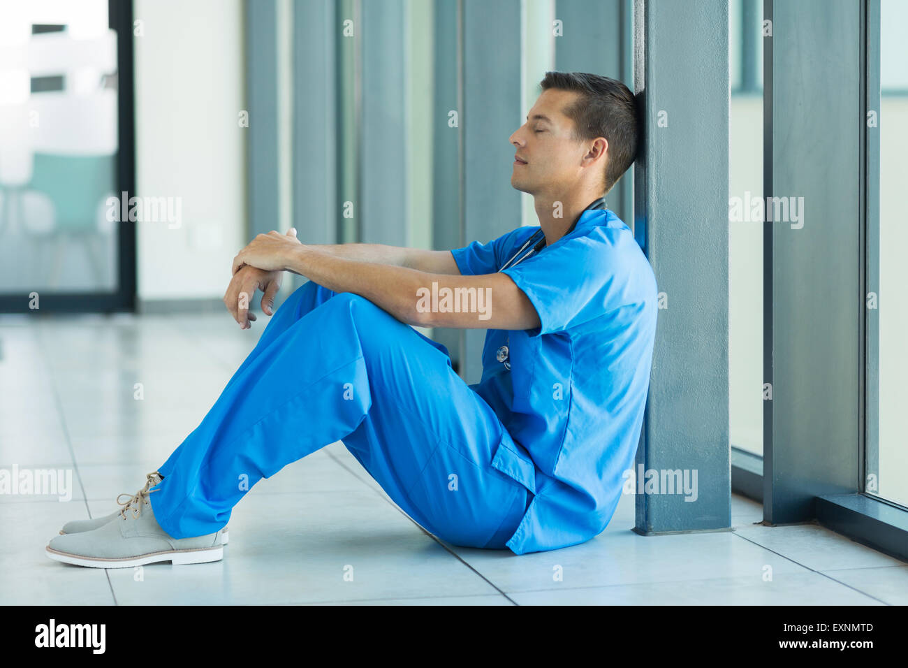 relaxed young doctor sitting on the floor Stock Photo - Alamy