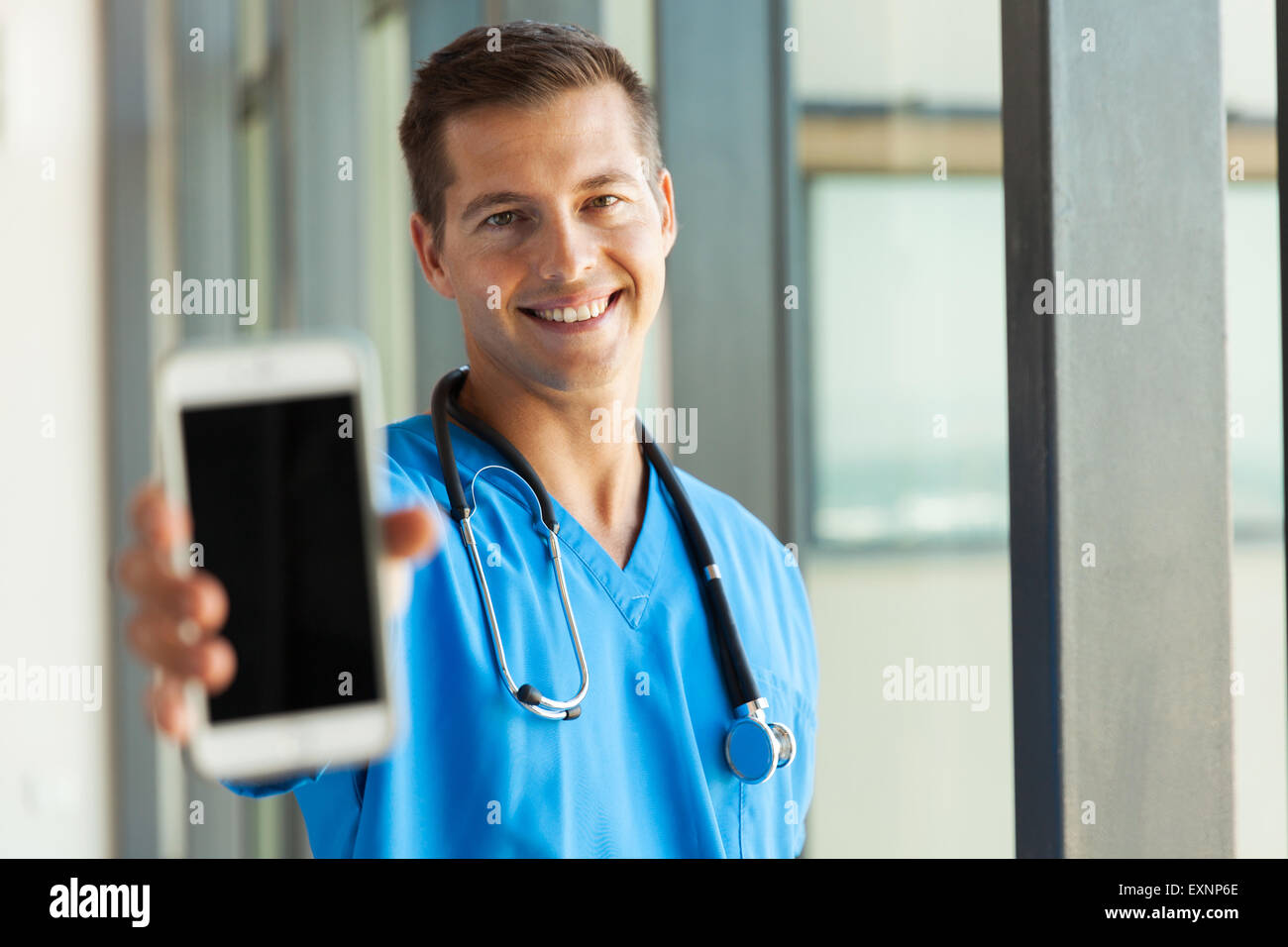 cheerful male doctor holding smart phone in hospital Stock Photo - Alamy
