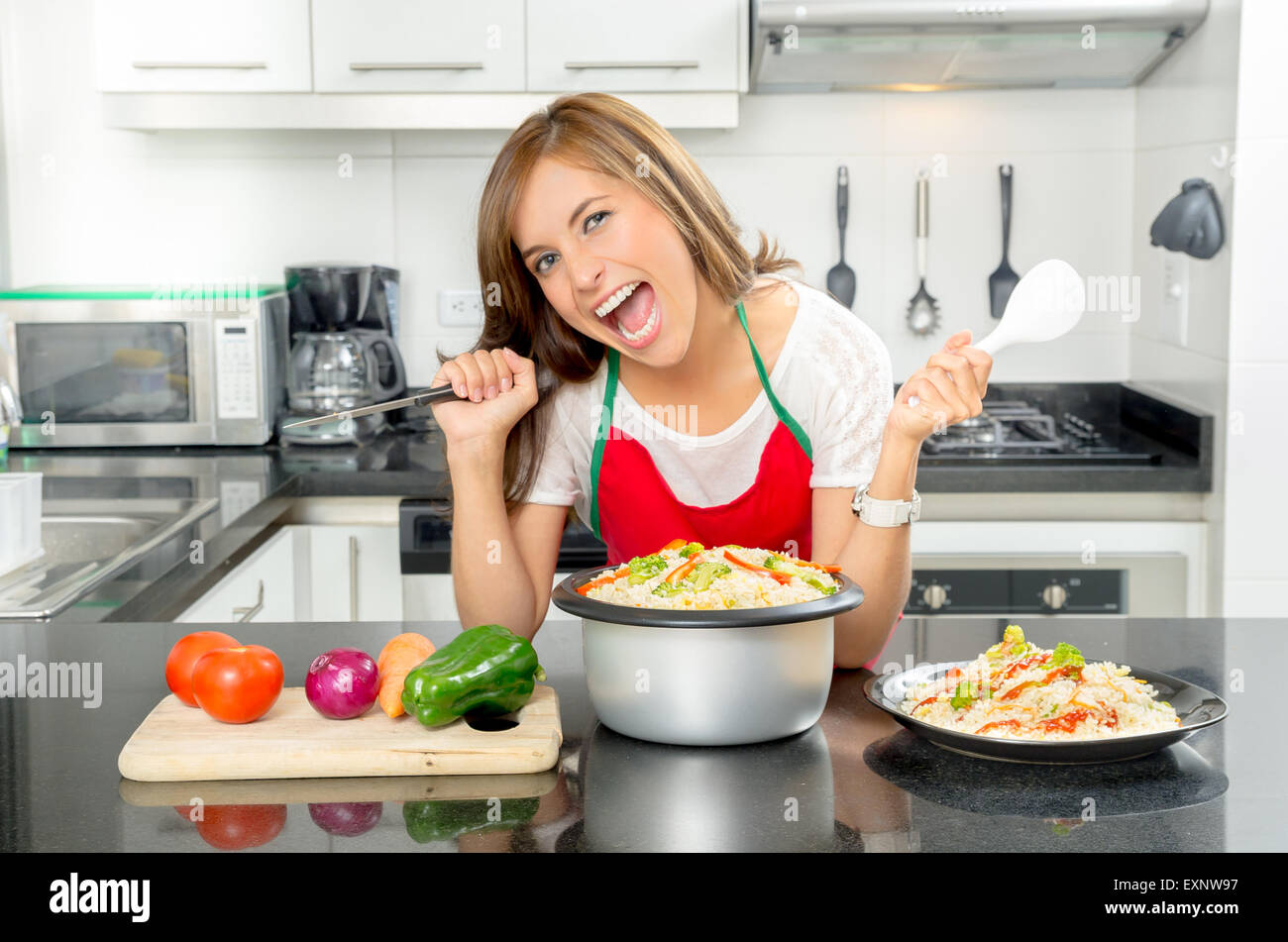 Hispanic beautiful woman cooking in modern kitchen by bench with ...