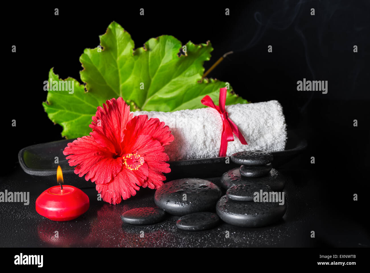 beautiful spa still life of red hibiscus flower with dew, candles ...