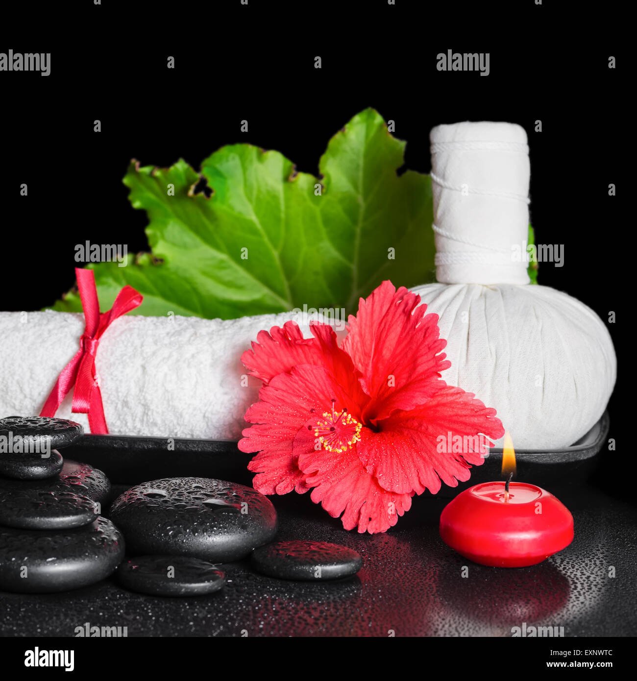 spa still life of red hibiscus flower with dew, candles, leaf, thai ...