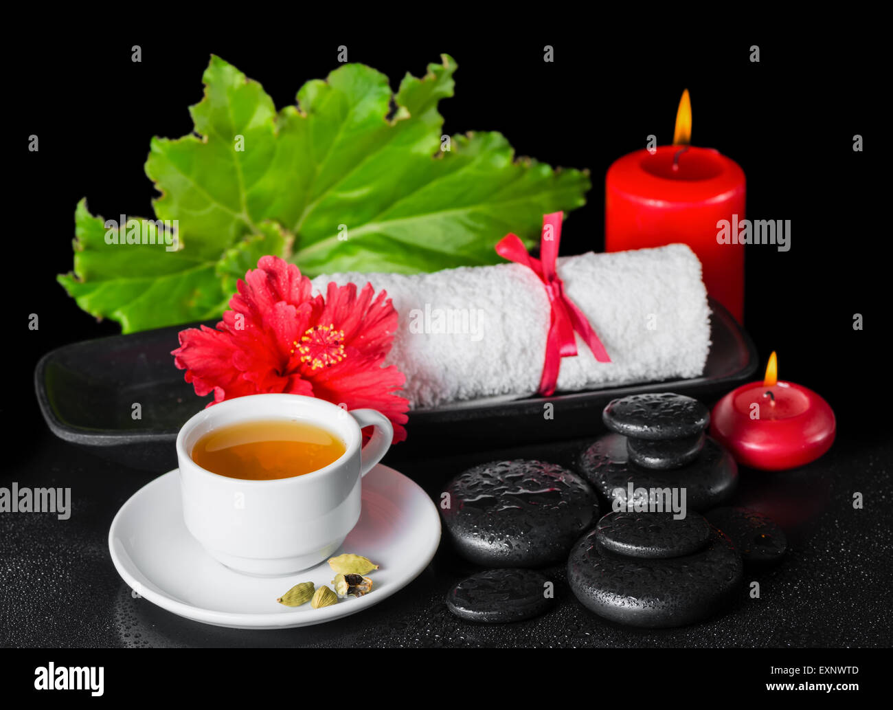 beautiful spa still life of red hibiscus flower with dew, candles ...