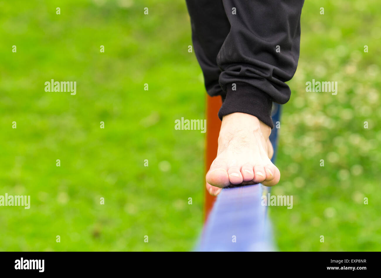 Closeup of mans feet balancing a tightrope or slackline in park ...