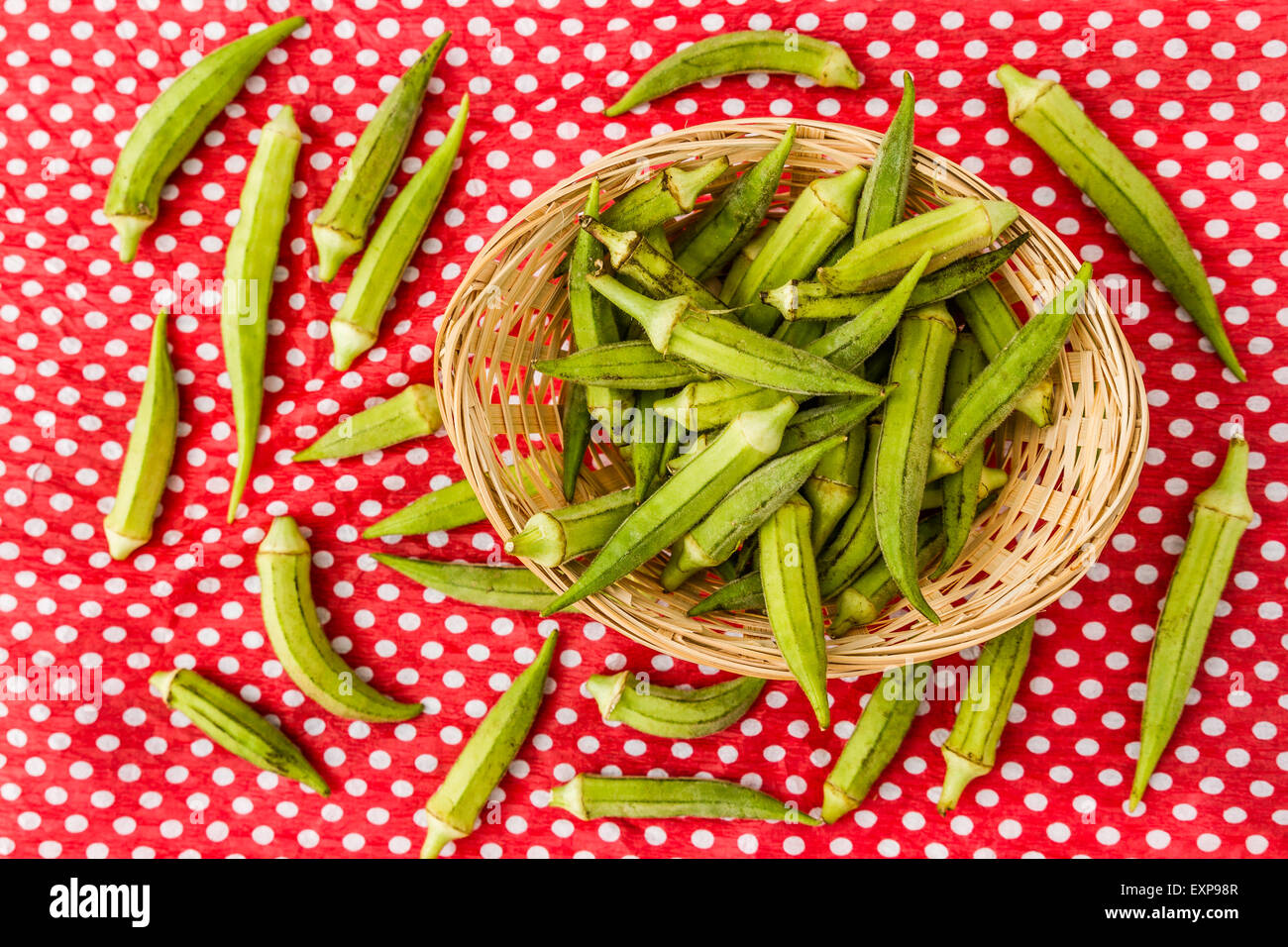 Organic green okra vegetable on red napkin with dots Stock Photo - Alamy