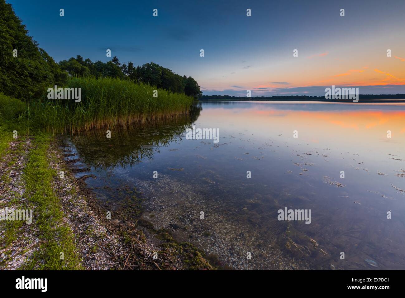 Beautiful lake at sunset landscape with cloudy sky reflecting in water ...