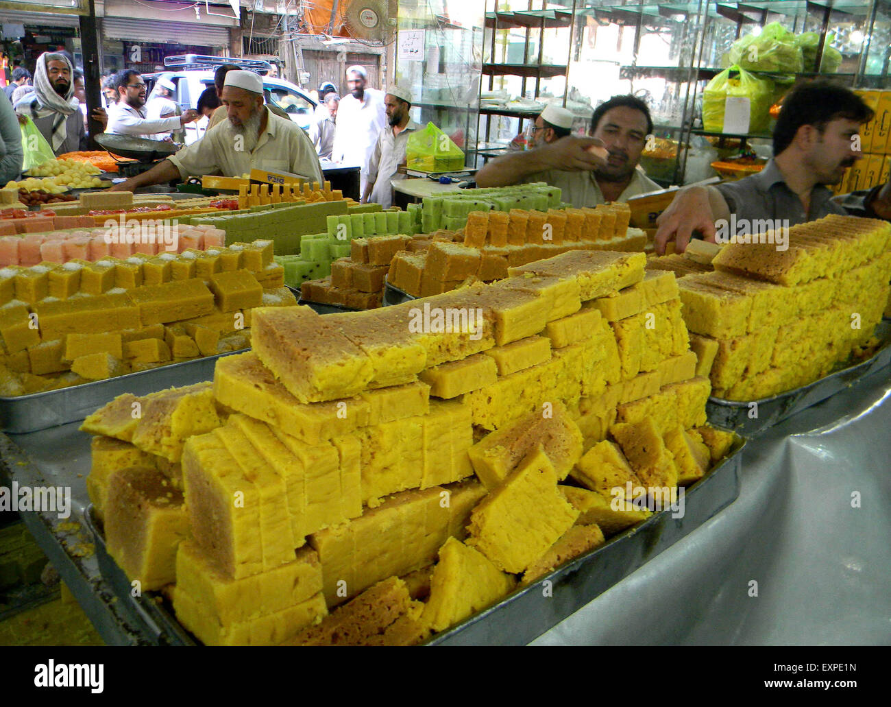 Peshawar. 16th July, 2015. People buy traditional sweets at a bakery ...