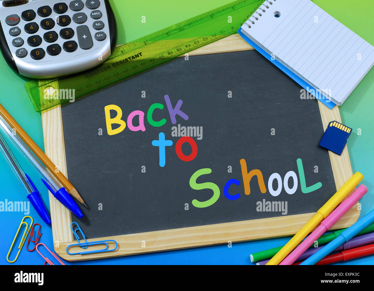 Back to school message on blackboard with school supplies surrounding ...