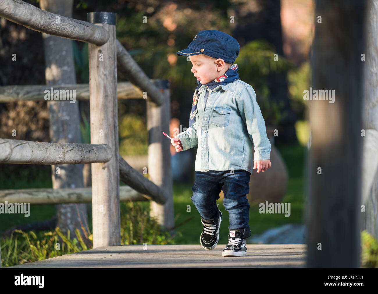 Young child walking across a wooden bridge Stock Photo - Alamy