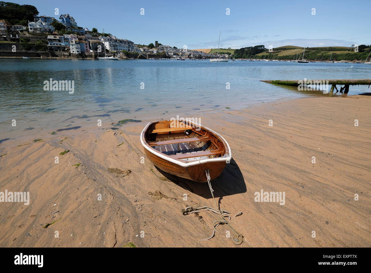 Salcombe, Devon, UK. Wooden rowing boat on the sunny beach at East ...