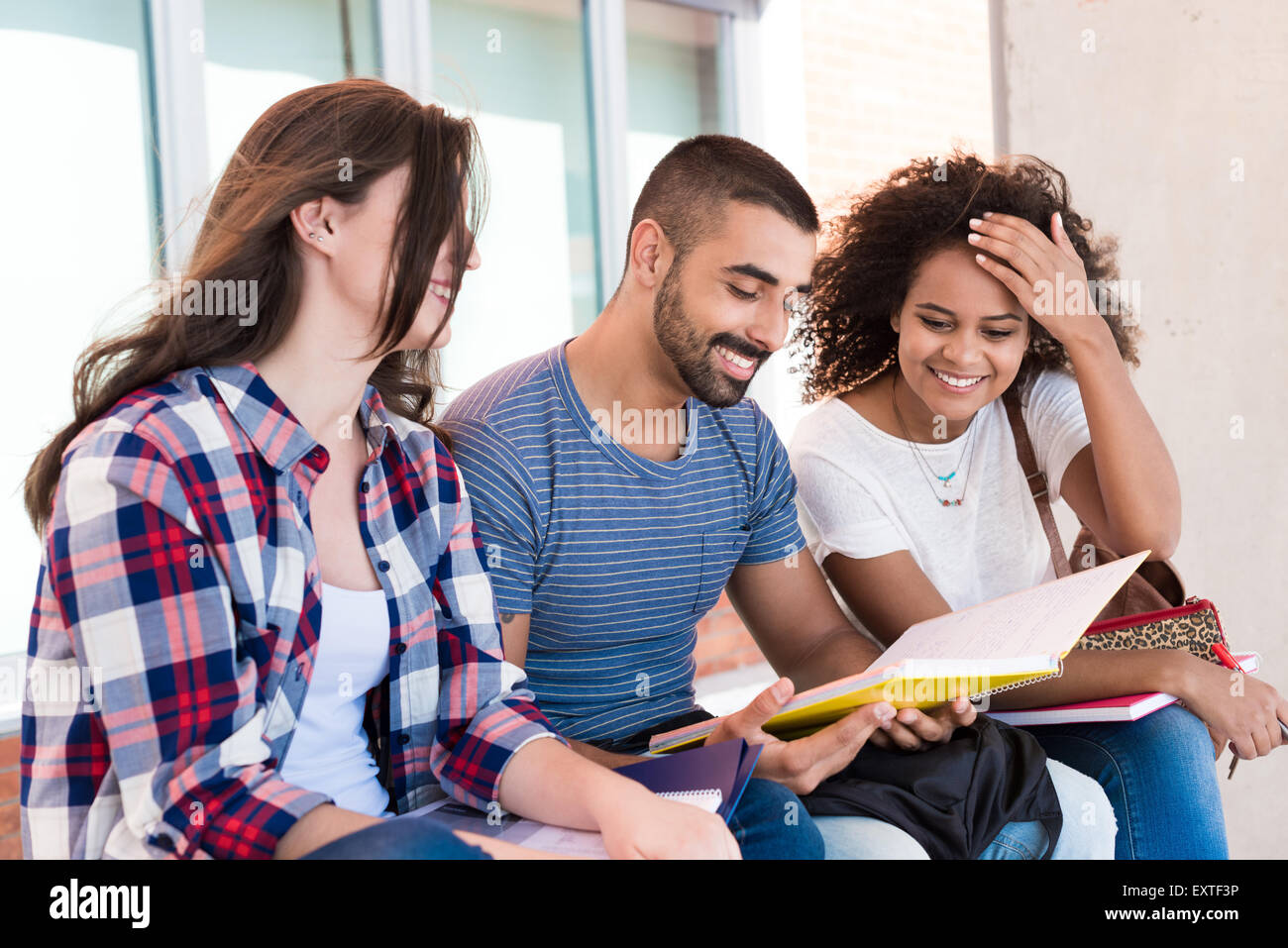 Students sharing notes in the university campus Stock Photo - Alamy