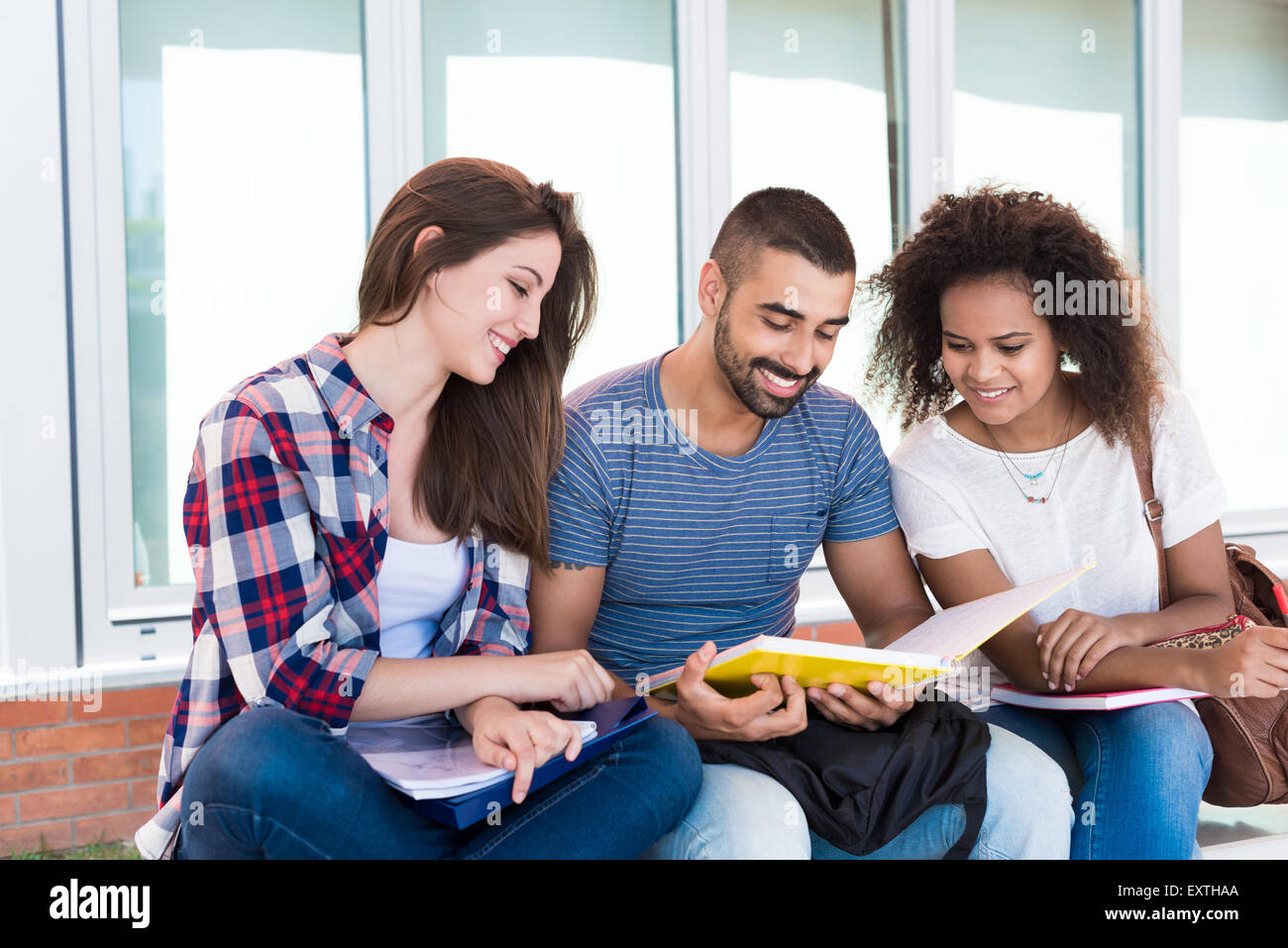Students sharing notes in the university campus Stock Photo - Alamy