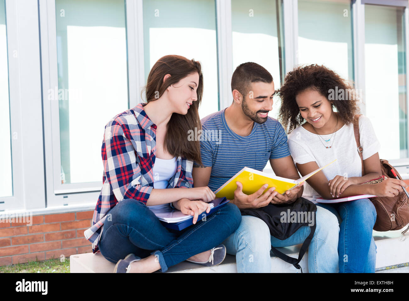 Students sharing notes in the university campus Stock Photo - Alamy