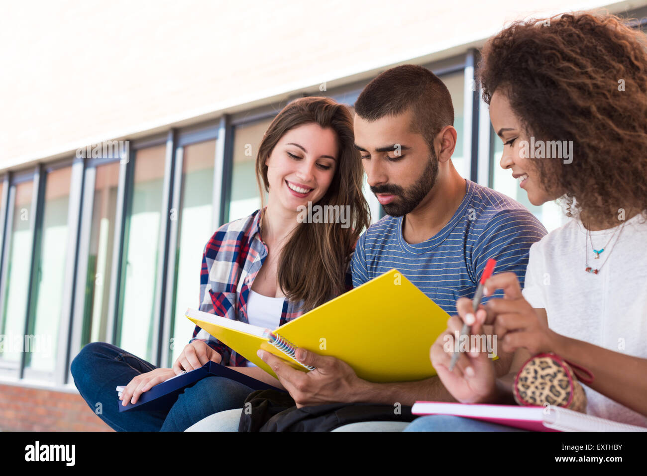 Students sharing notes in the university campus Stock Photo - Alamy