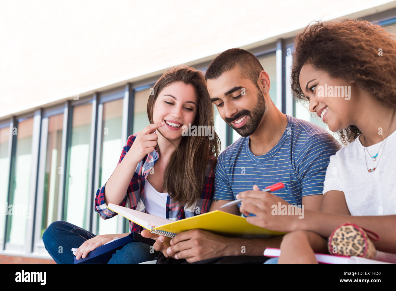 Students sharing notes in the university campus Stock Photo - Alamy