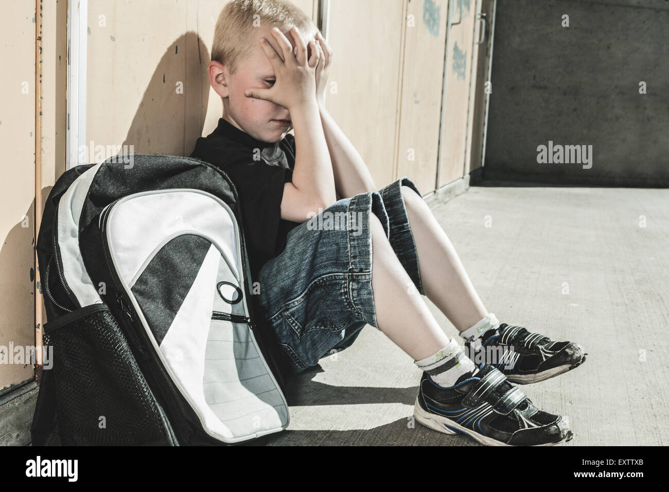 A very sad boy in school playground Stock Photo - Alamy