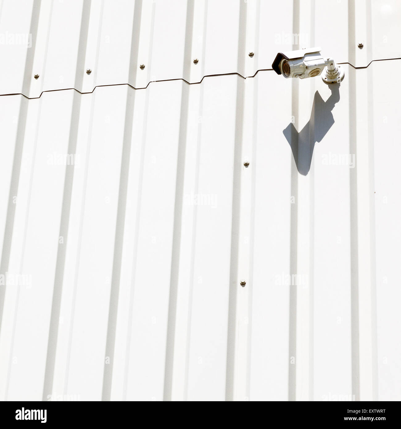 surveillance camera on wall of white industrial metal building Stock ...