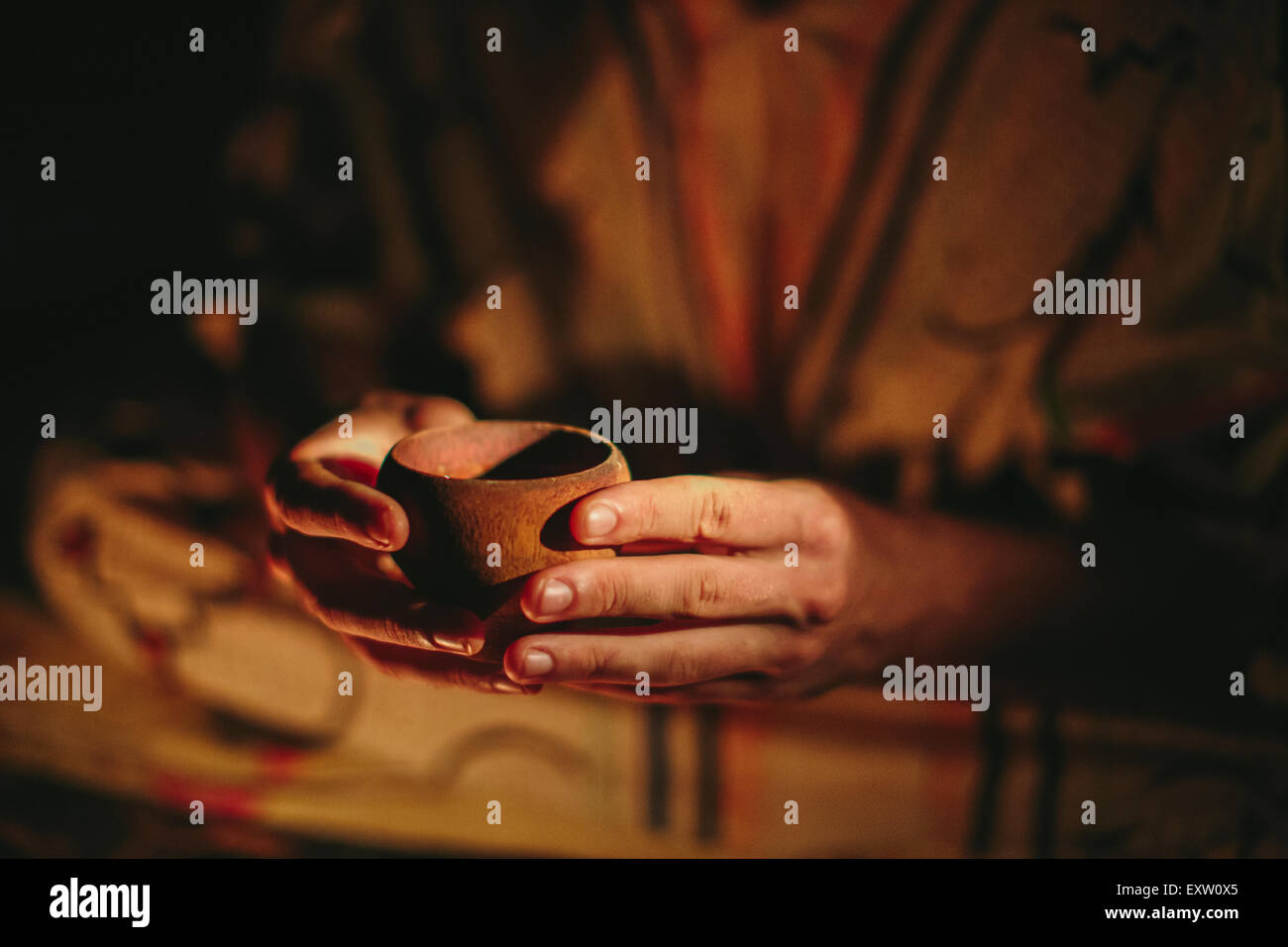 A Shipibo curandero holds out a cup of Ayahuasca, a traditional ...