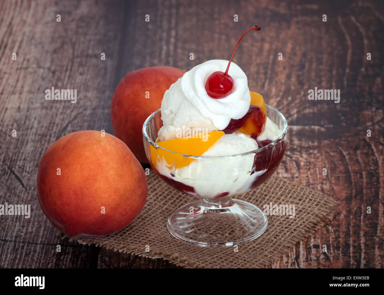 Vanilla peach melba ice cream with peach fruits on wooden dark vintage ...