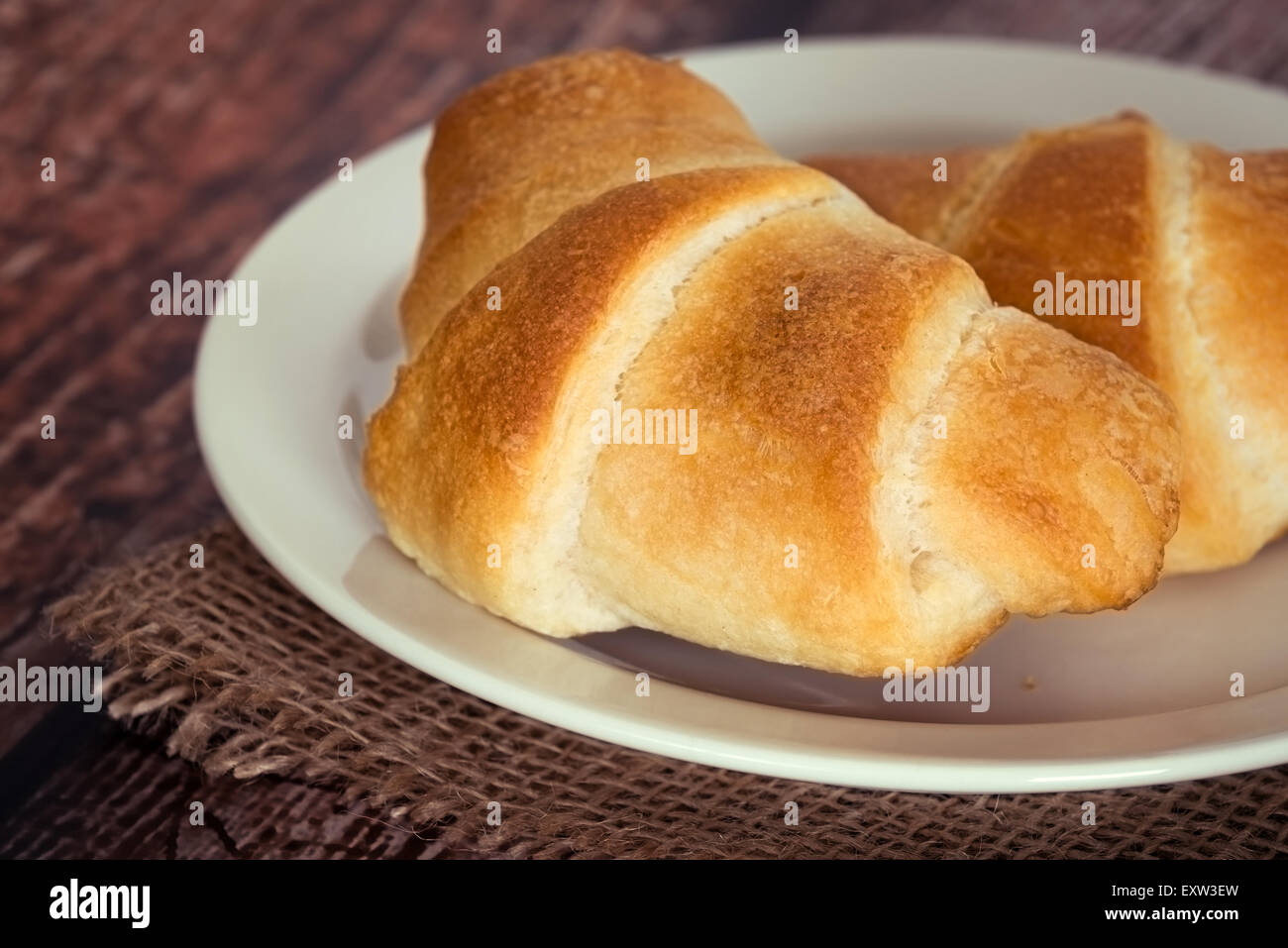 Closeup of breakfast croissants on a plate against vintage rustic ...