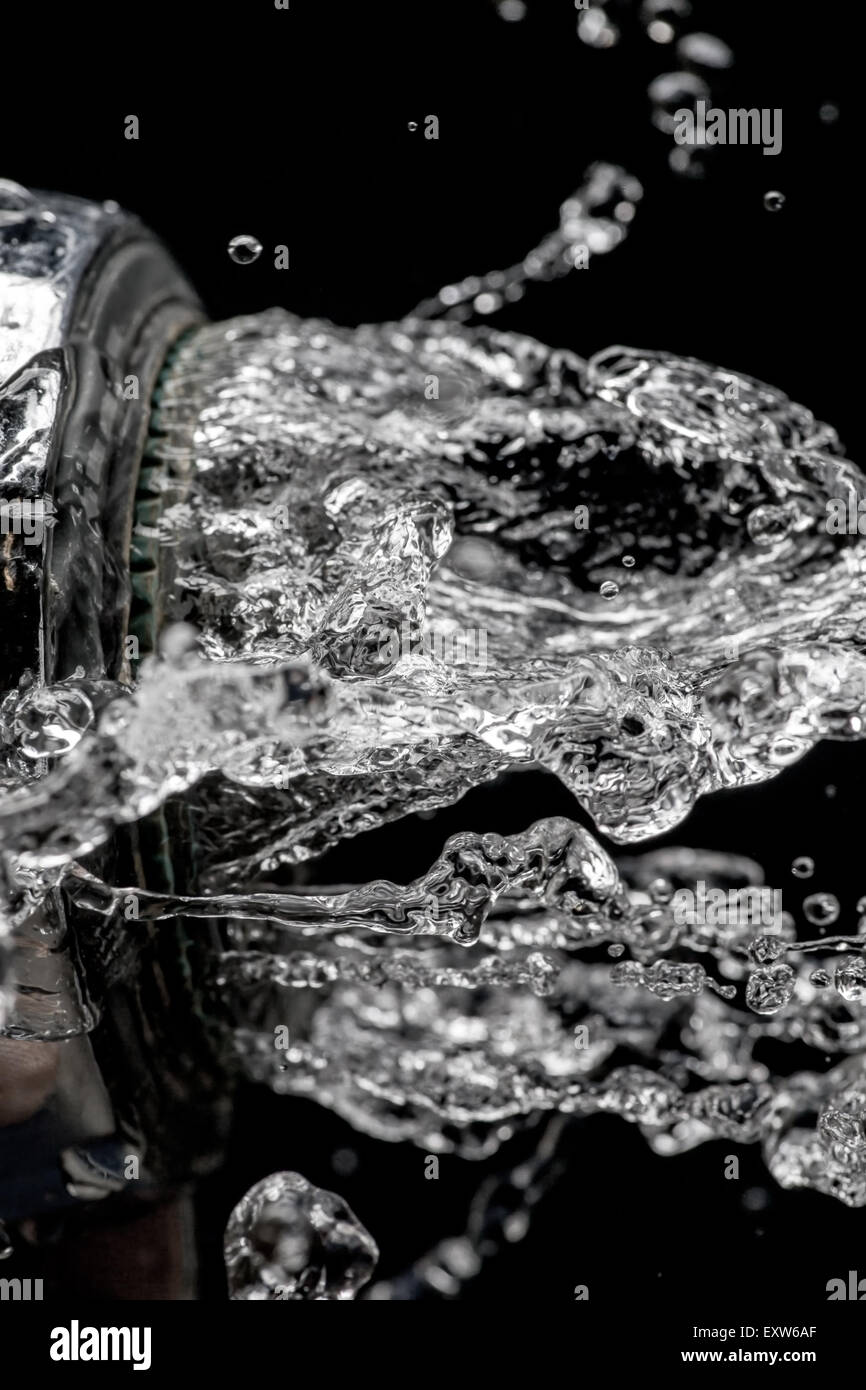 Shower head macro shot with freezed water lwvitate in the air on black ...