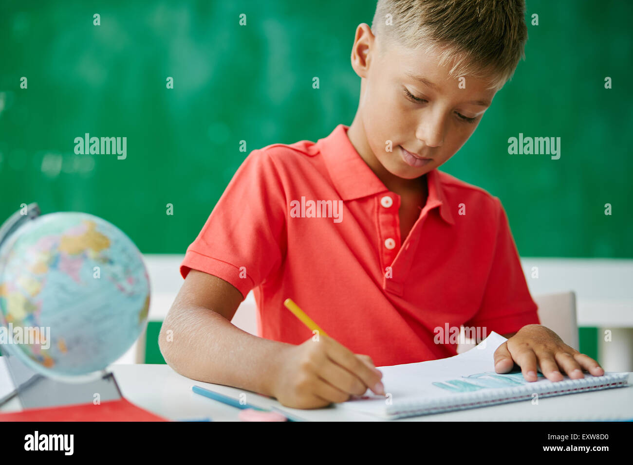Clever schoolboy drawing at lesson in school Stock Photo - Alamy