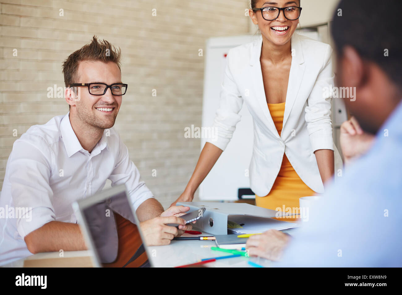 Smiling business partners talking to colleagues at meeting Stock Photo ...