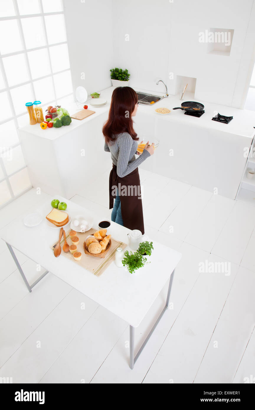 Young woman standing in the kitchen Stock Photo - Alamy