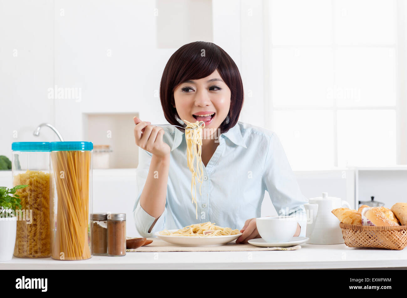 Young woman eating spaghetti and smiling at the camera Stock Photo - Alamy