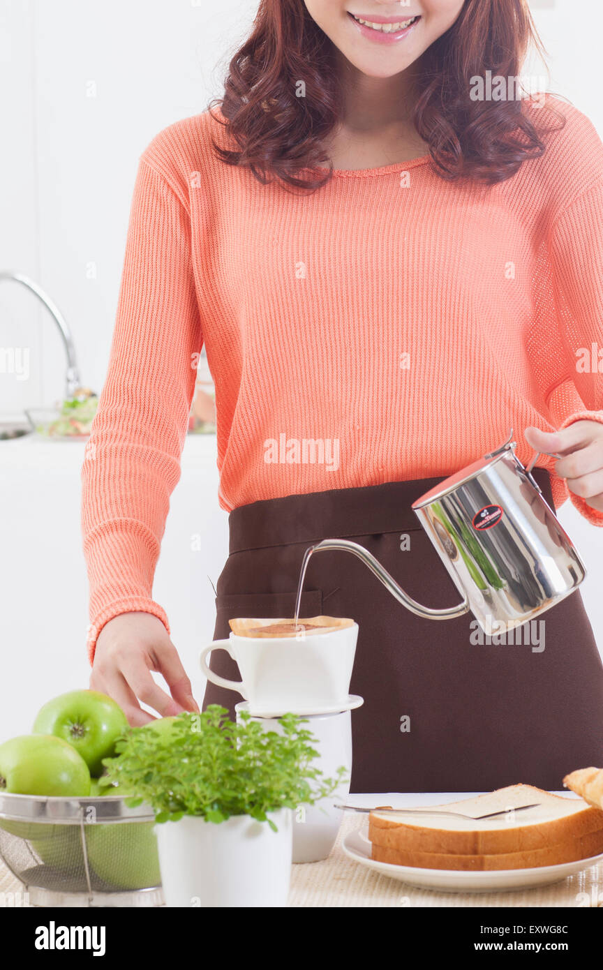 Young woman making coffee with smile Stock Photo - Alamy